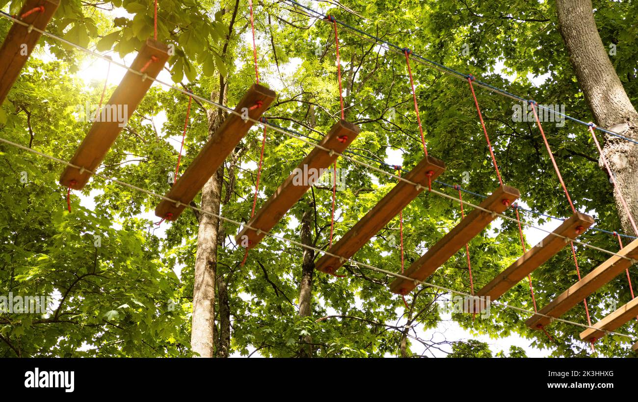 Rope town on the background of trees. Entertainment in the park for ...