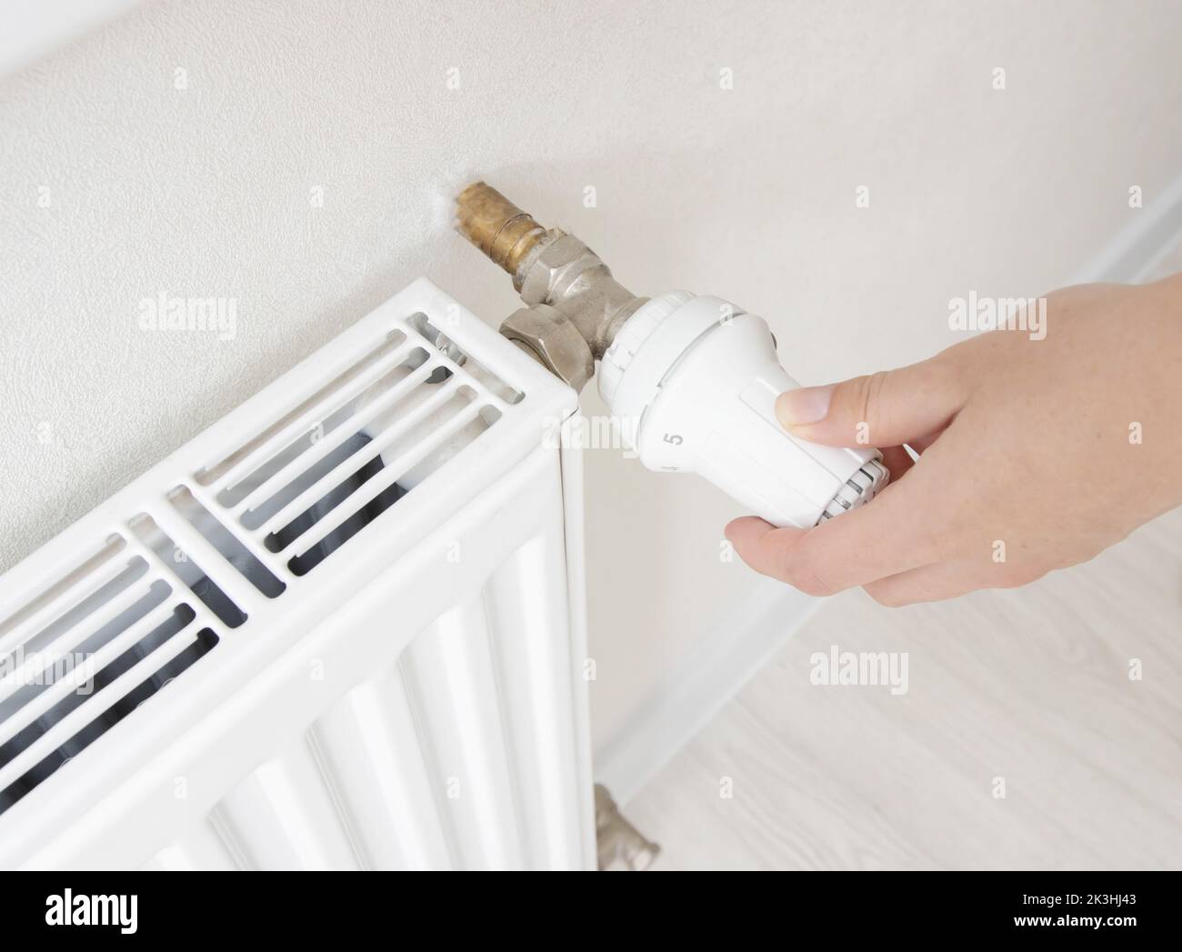 Adjustment of comfortable temperature on the wall radiator in the house ...