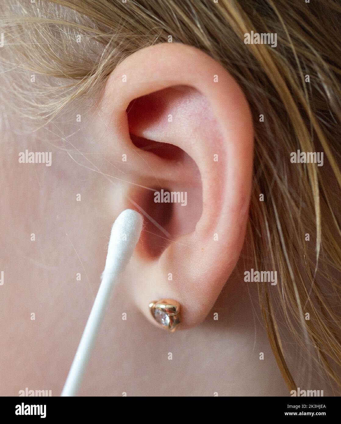 Cleaning a child's ear with a cotton swab from contamination of the ear ...