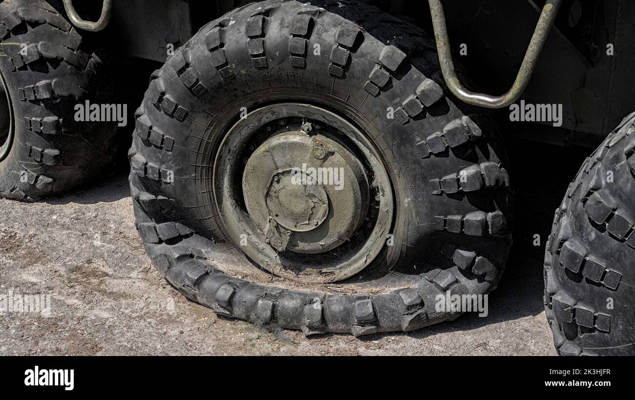 A punctured and flat tire of military equipment of the armored ...