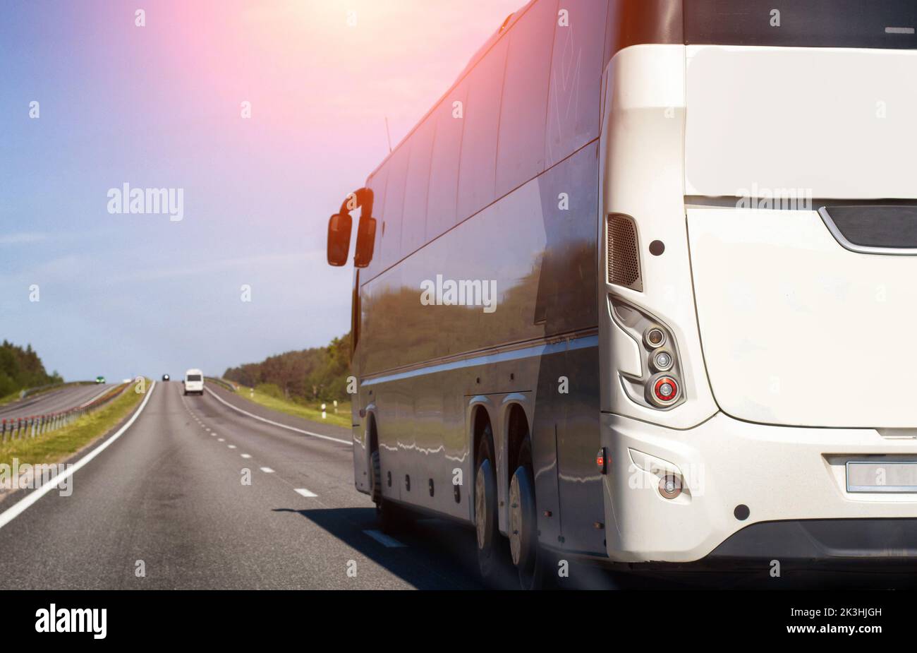 New modern passenger bus on the road in summer against the blue sky ...