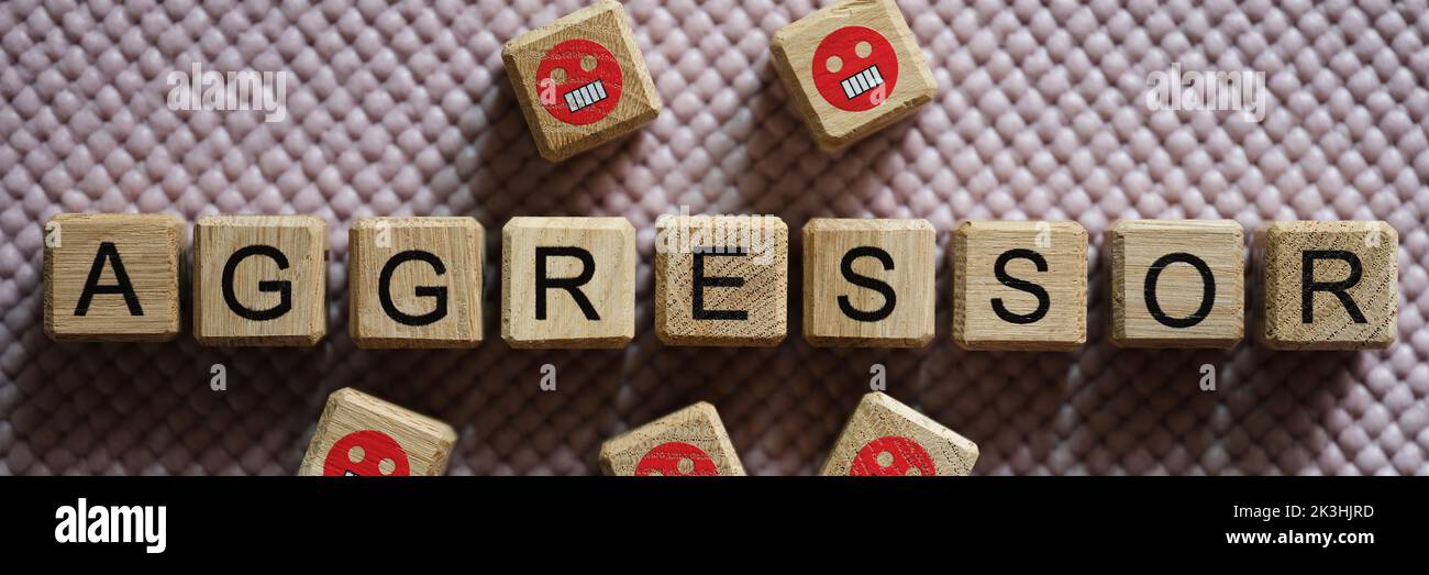 Text aggressor on cubes and angry emoticons closeup Stock Photo - Alamy