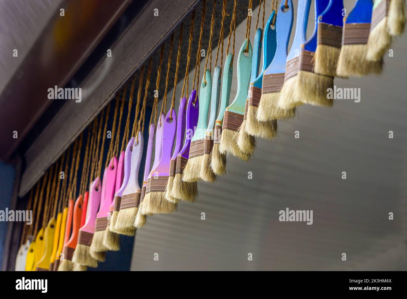 A set of multi-colored brushes hanging over the display case Stock ...