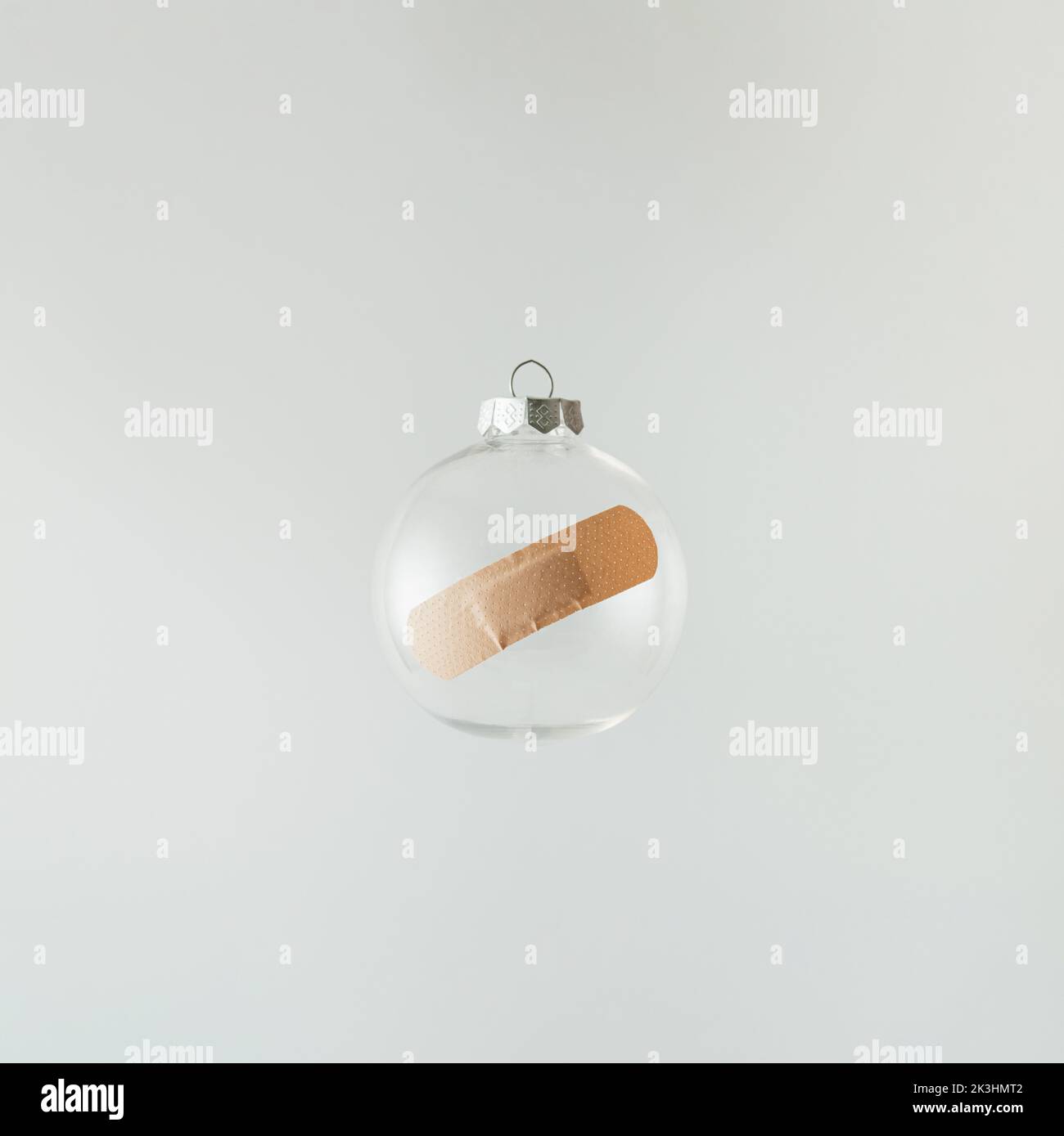 Transparent Christmas bauble with adhesive bandage levitating against ...