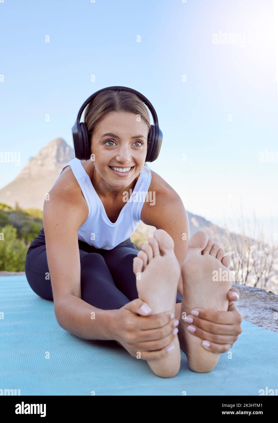 Outdoor yoga, stretching and woman with headphones listening to ...