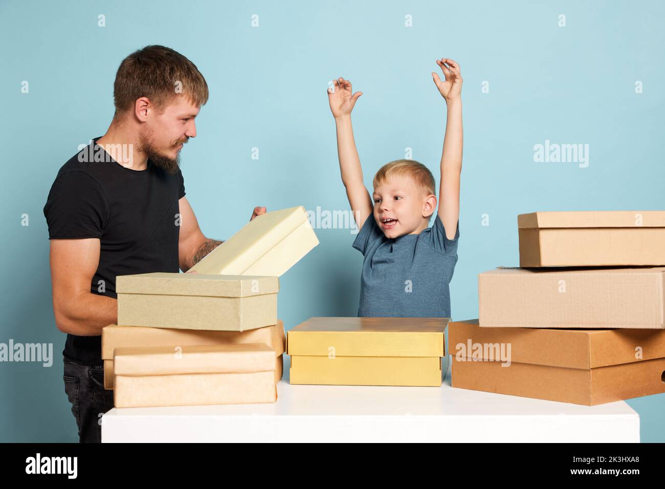 Happy emotions. Young father and child open cardboard boxes, receive ...