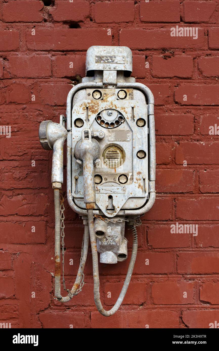 Old vintage telephone on a street brick wall. Steampunk technology ...