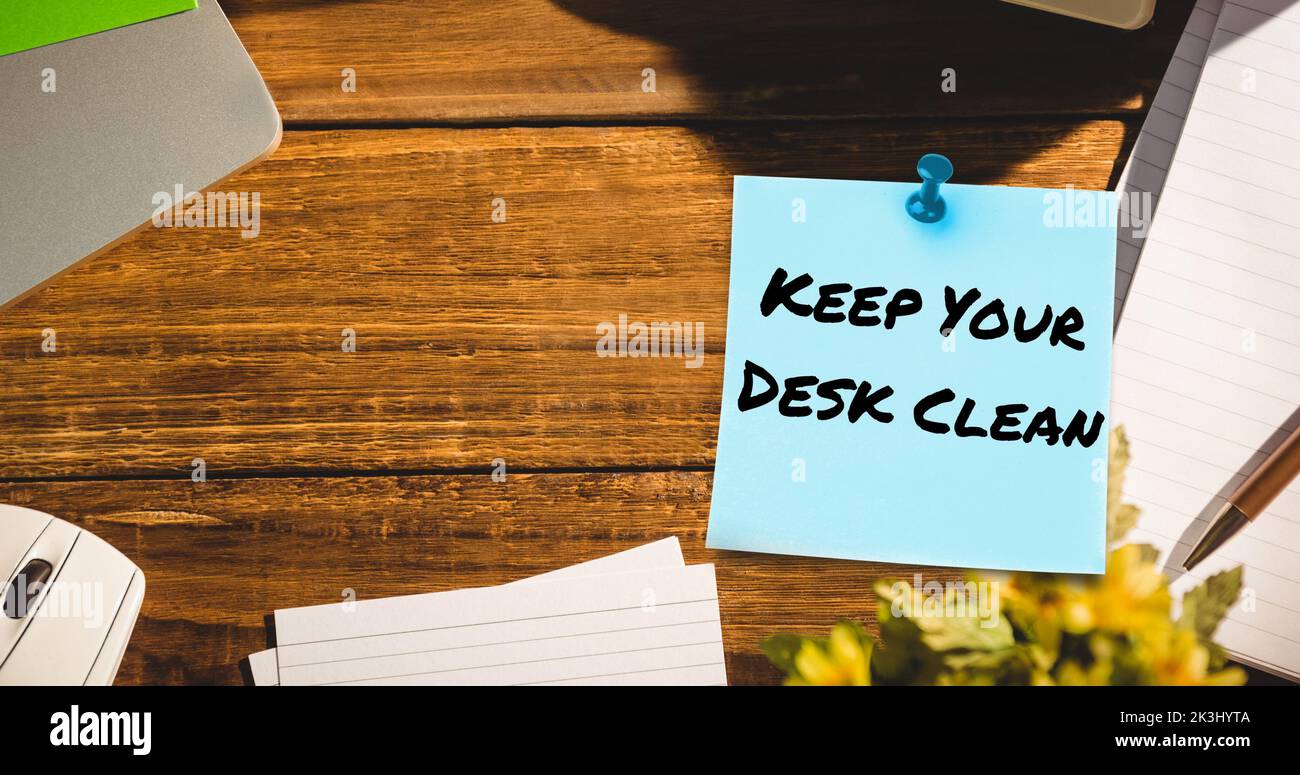 Composite of keep your desk clean text on sticky note with office ...