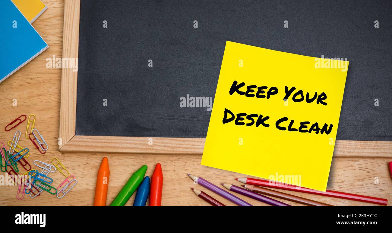 Composite of keep your desk clean text on sticky note with slate and ...
