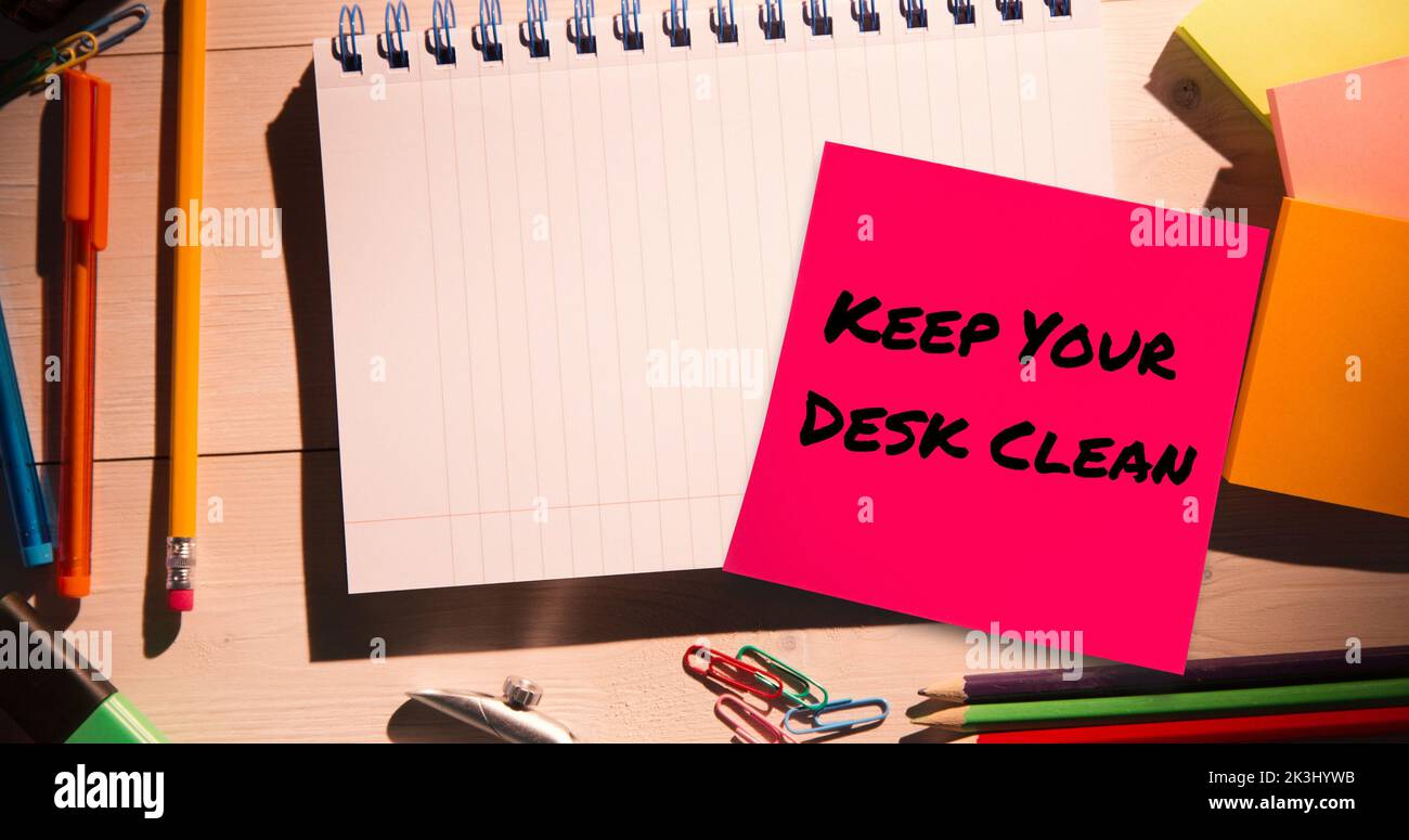 Composite of keep your desk clean text on sticky note and high angle ...