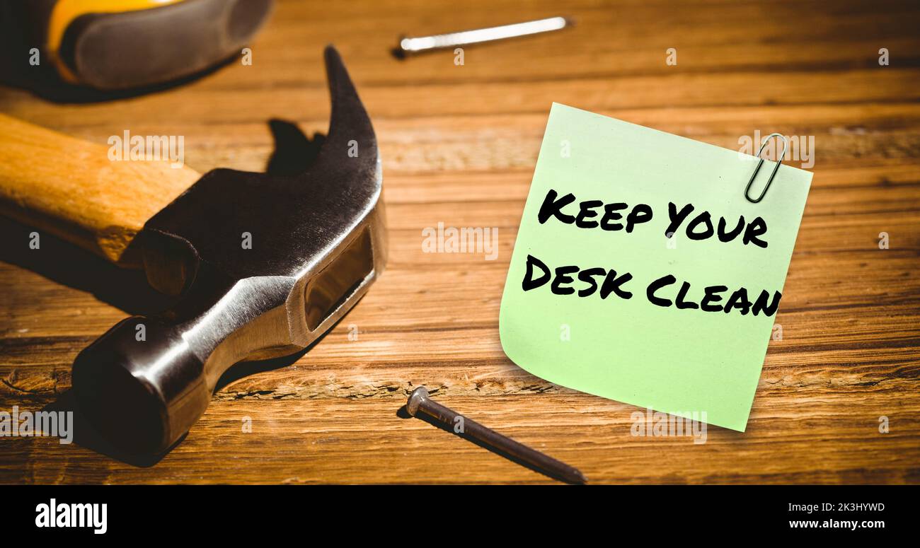 Composite of sticky note with keep your desk clean text with hammer and ...