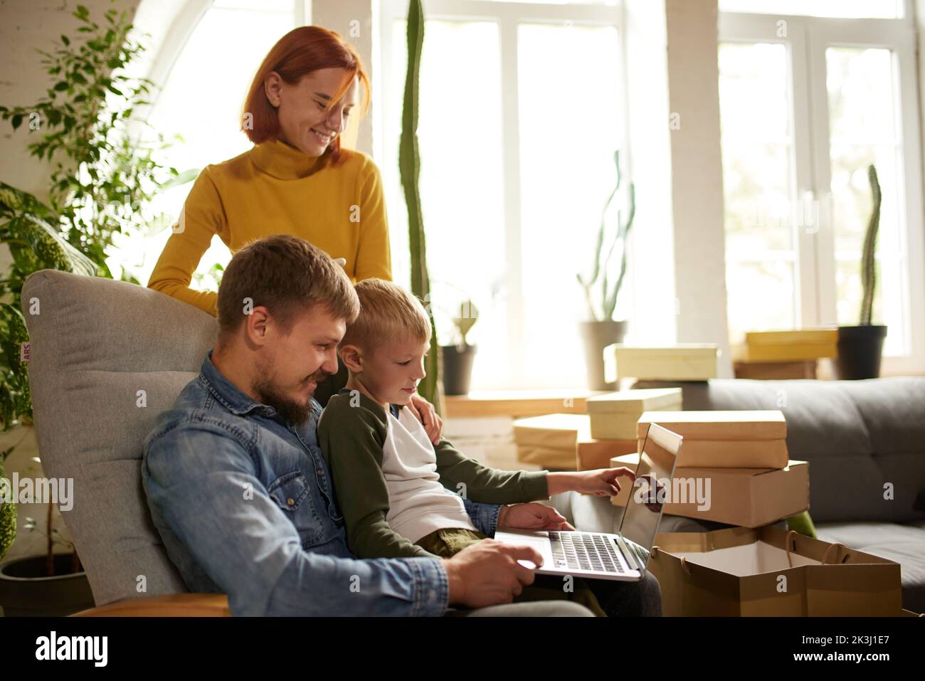 Young happy family, parents and kid using laptop making online order ...