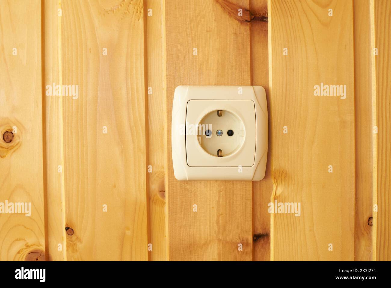 Electric socket on wooden wall, fire safety concept Stock Photo - Alamy