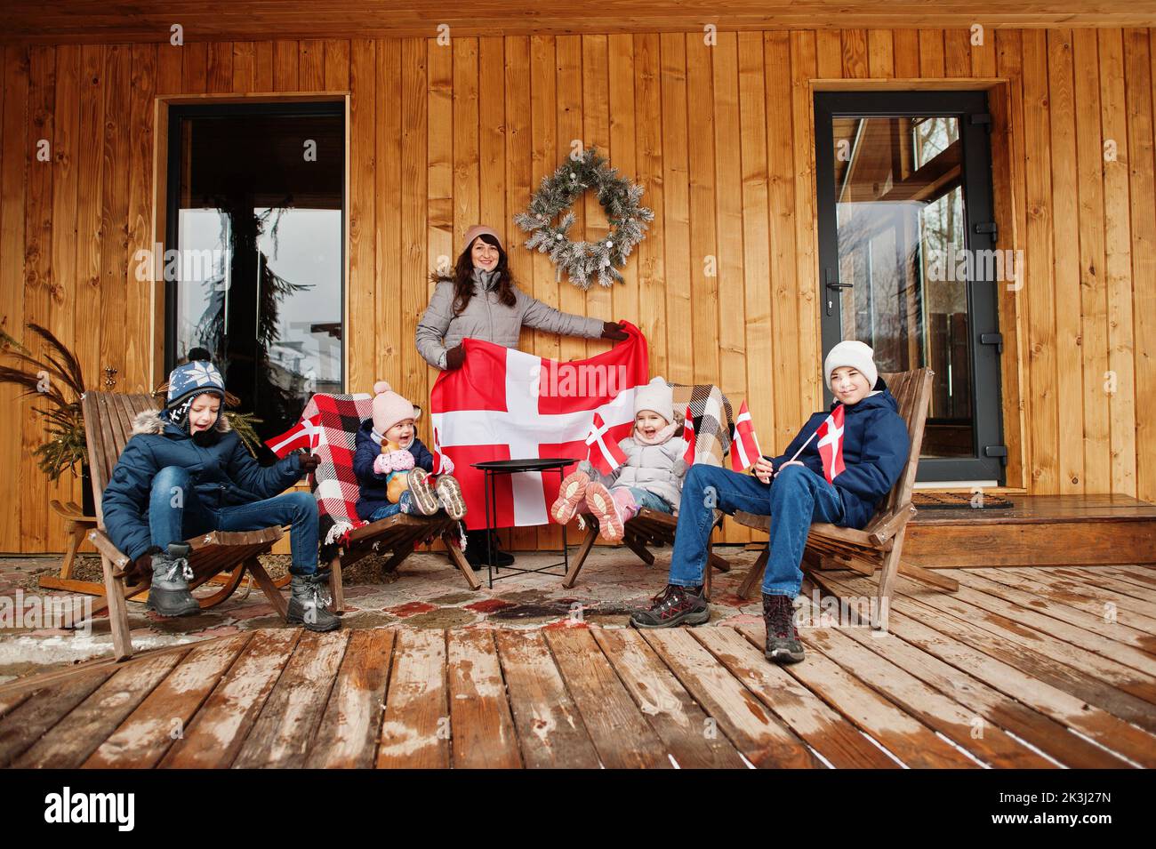 Family with Denmark flags near they wooden house. Travel to ...