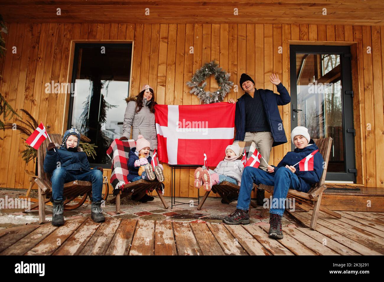 Family with Denmark flags near they wooden house. Travel to ...