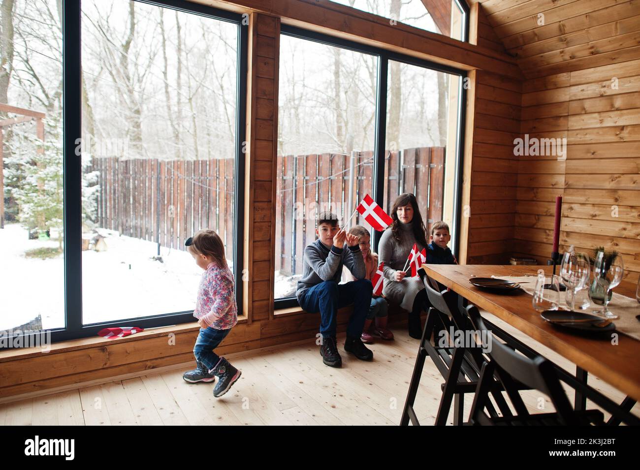 Family with Denmark flags inside wooden house. Travel to Scandinavian ...
