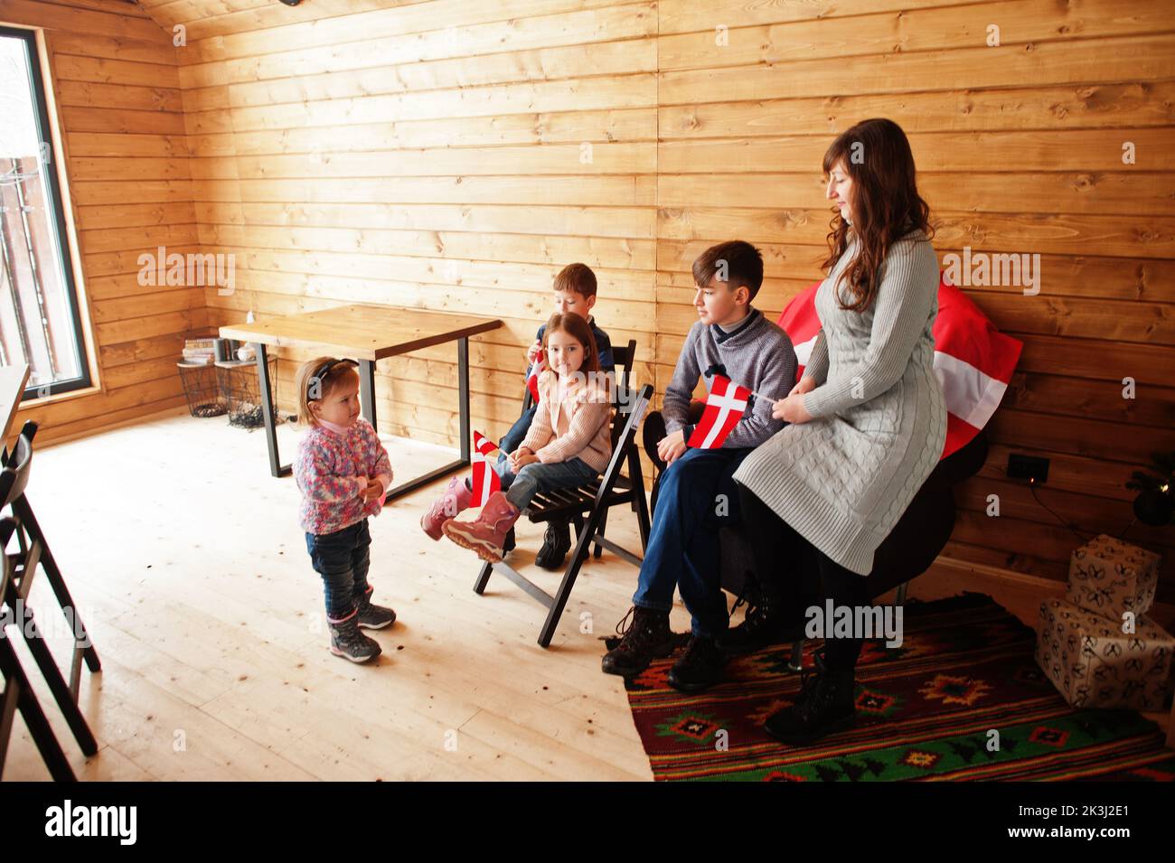 Family with Denmark flags inside wooden house. Travel to Scandinavian ...