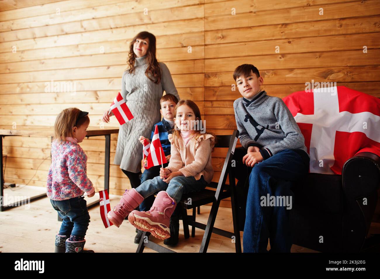 Family with Denmark flags inside wooden house. Travel to Scandinavian ...
