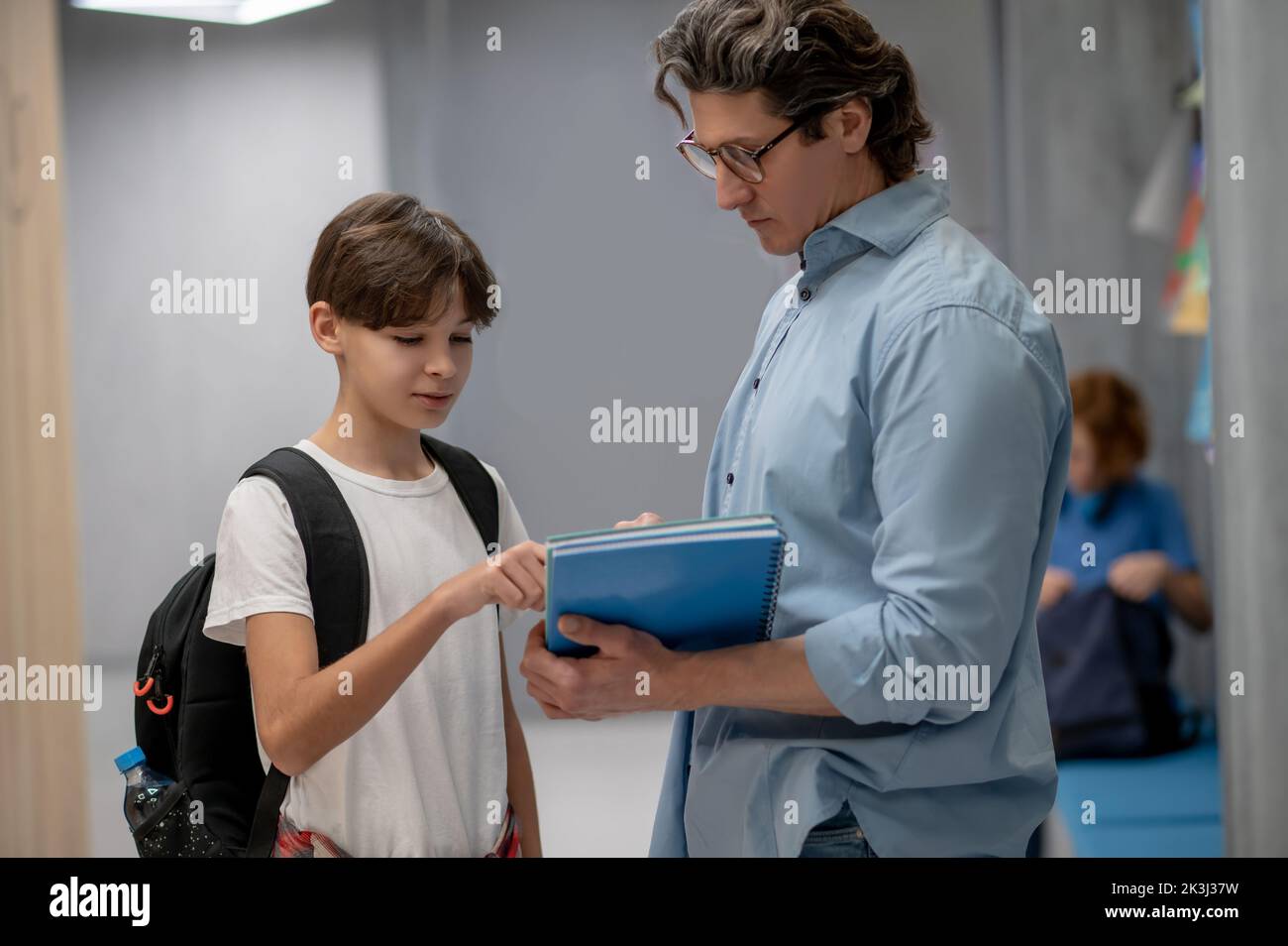 Schoolboy asking questions to his schoolteacher in the corridor Stock ...