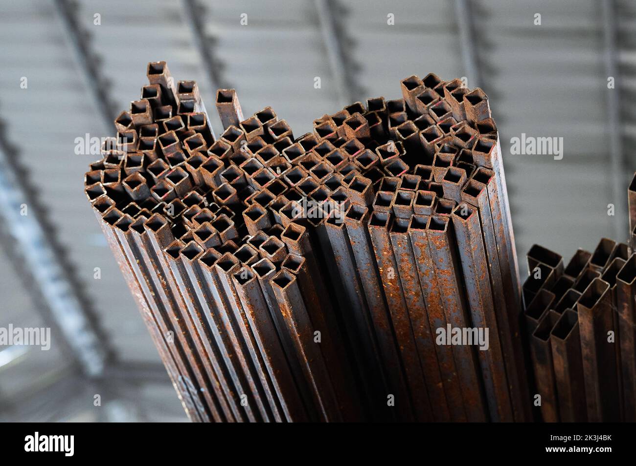 Square tubing pile on rack unit in cold factory warehouse Stock Photo ...