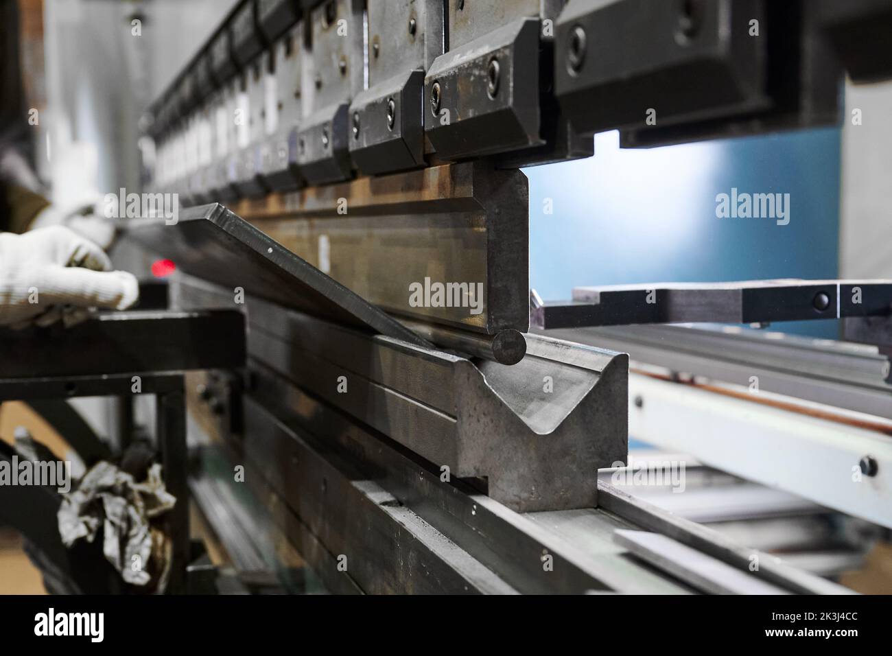Bending machine operates with heavy metal plate in shop Stock Photo - Alamy