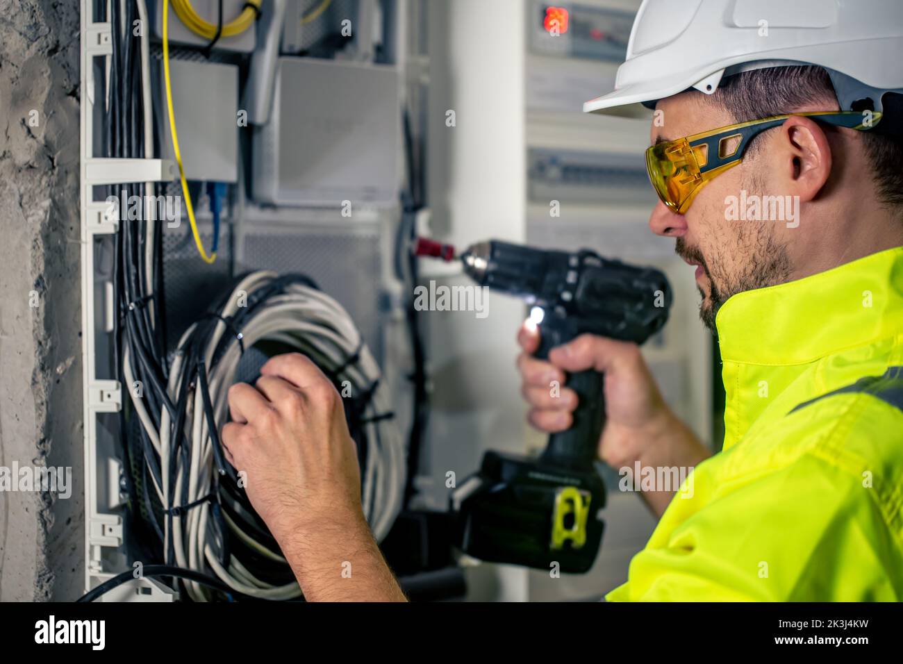Man, an electrical technician working in a switchboard with fuses Stock ...