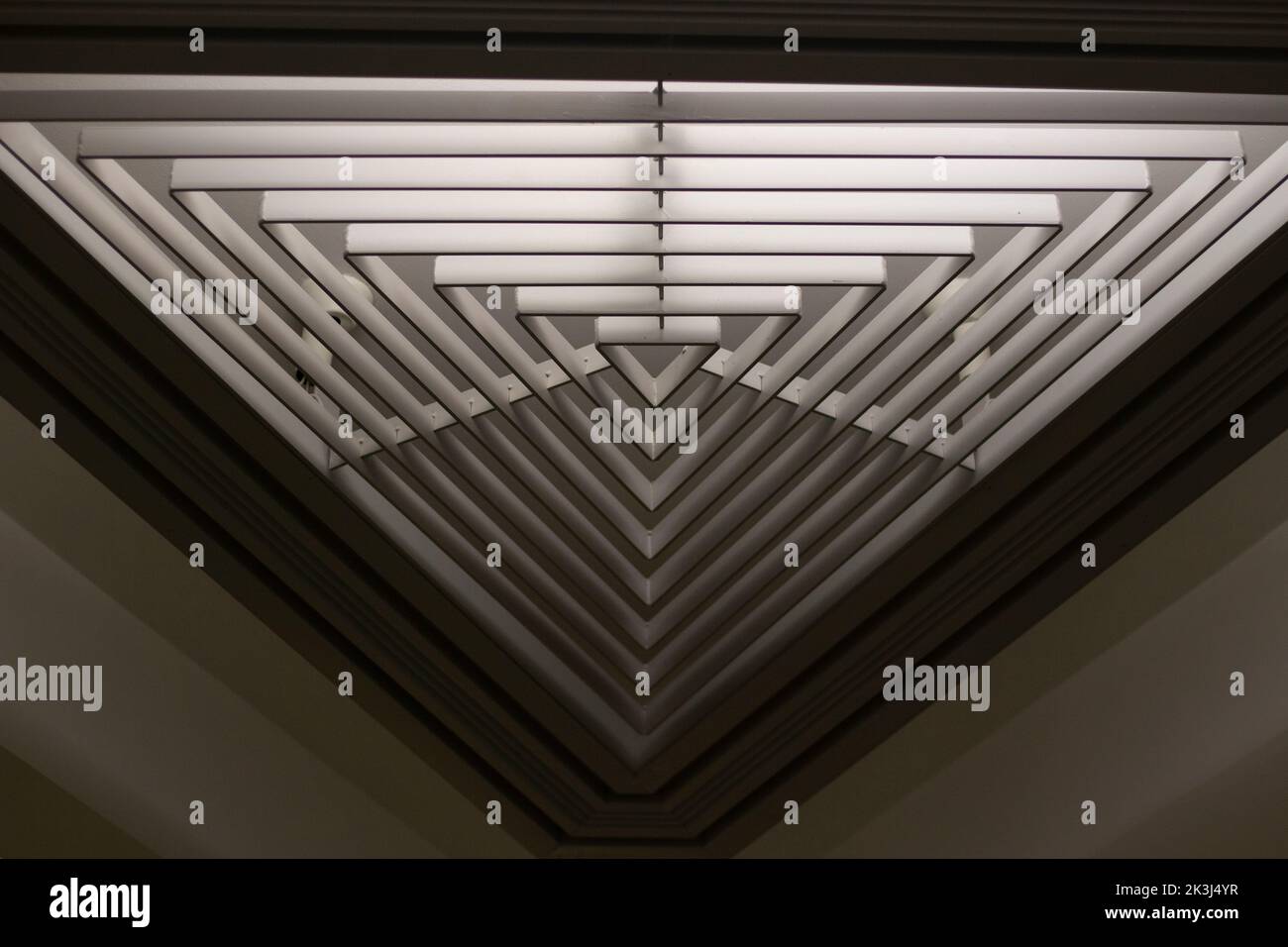 Triangular lamp in interior. Design of lighting device. Lamp on ceiling ...