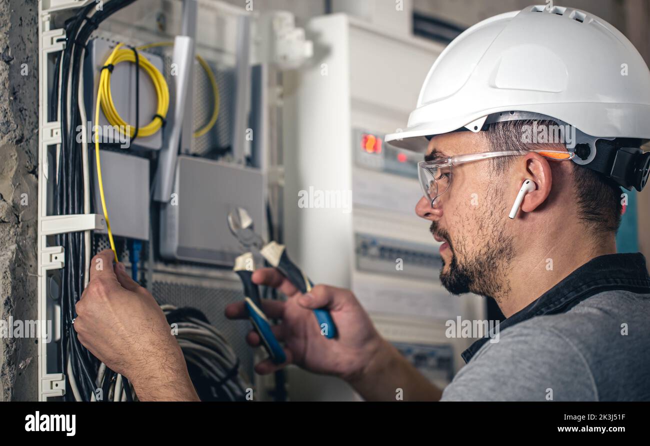 Man, an electrical technician working in a switchboard with fuses Stock ...