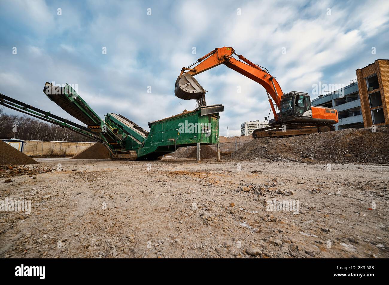 Excavator loads soil in mobile crushing and sorting complex Stock Photo ...