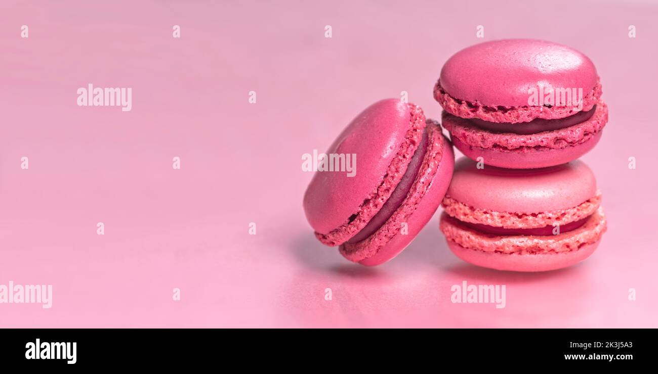 Multi-colored macaroons on a pink background. Panoramic image with copy ...