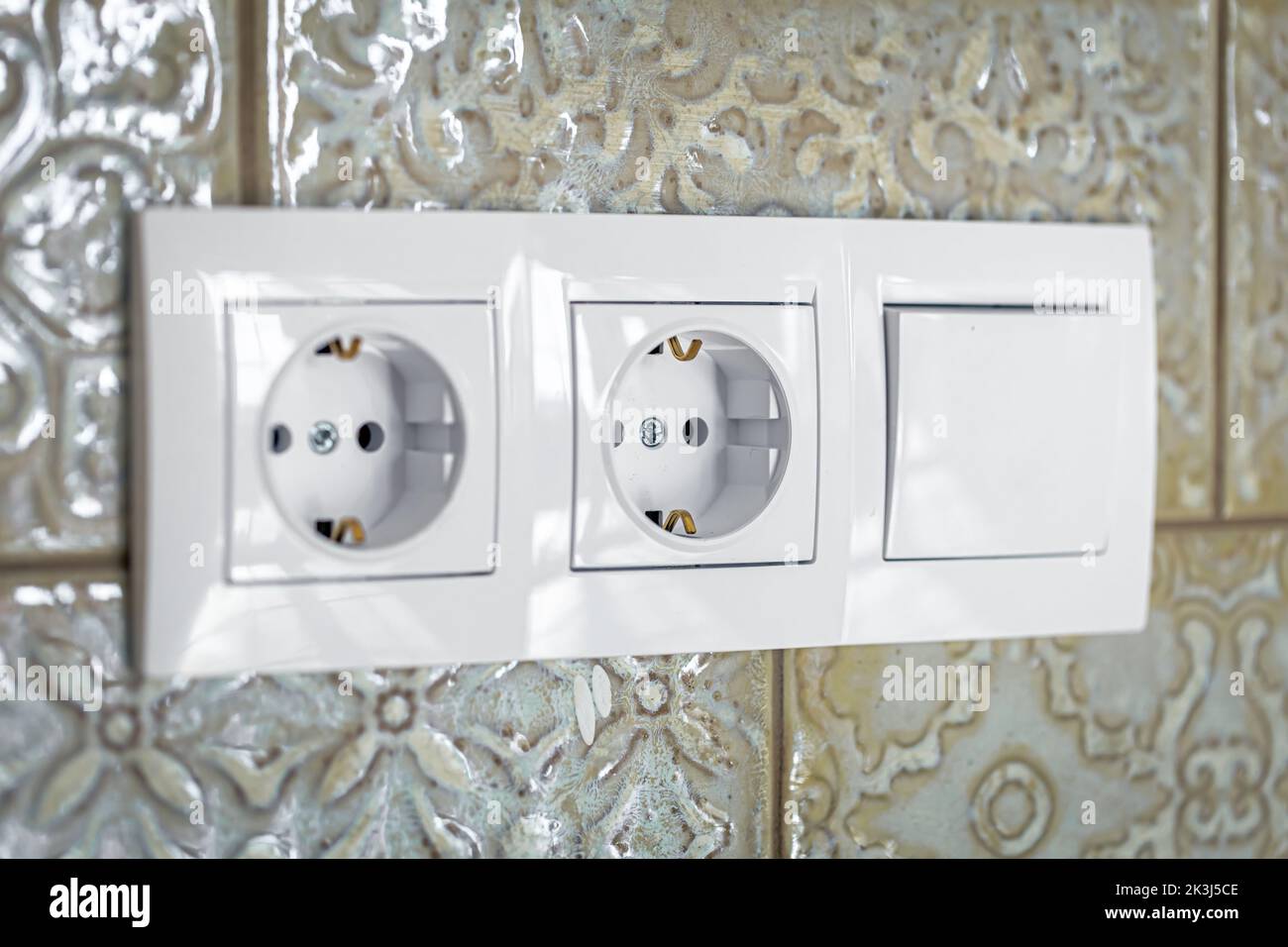 White plastic walk-through switches and sockets on a white wall Stock ...