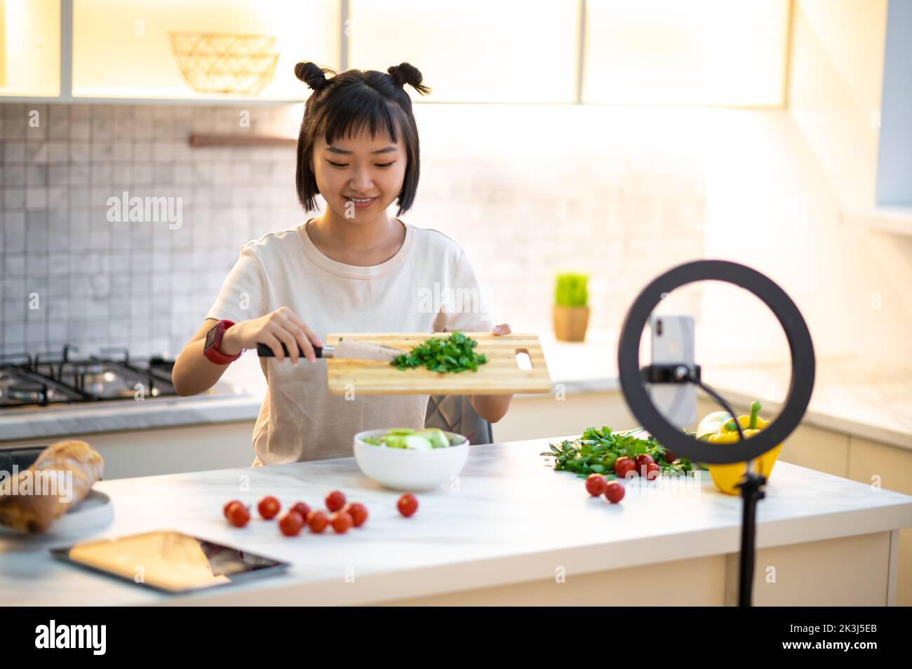 Female cook preparing a vegan dish in her cookery vlog Stock Photo - Alamy