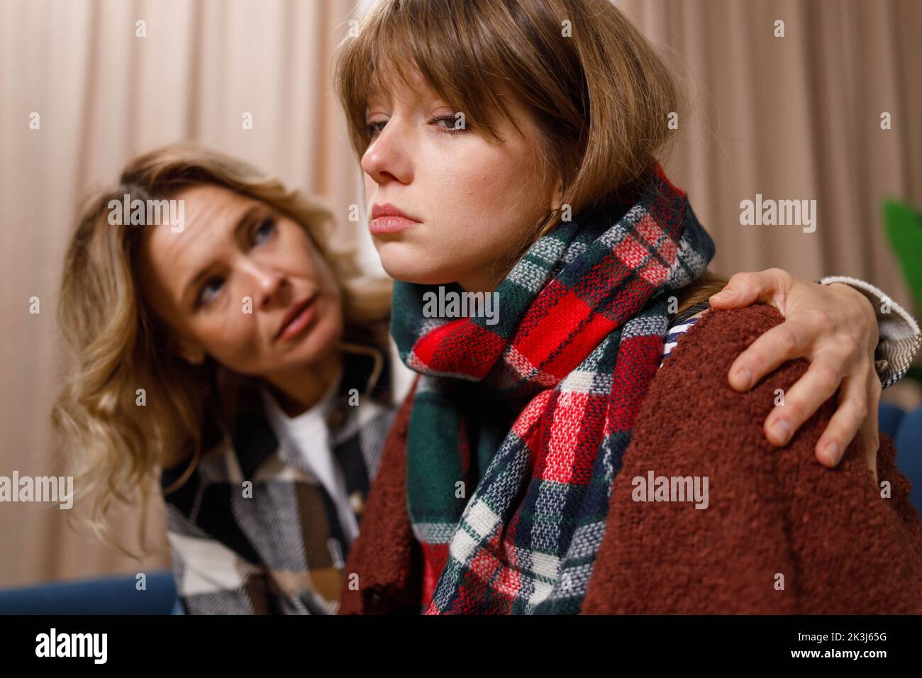 Mother supporting her flu-sick daughter. Woman supports a sad girl ...