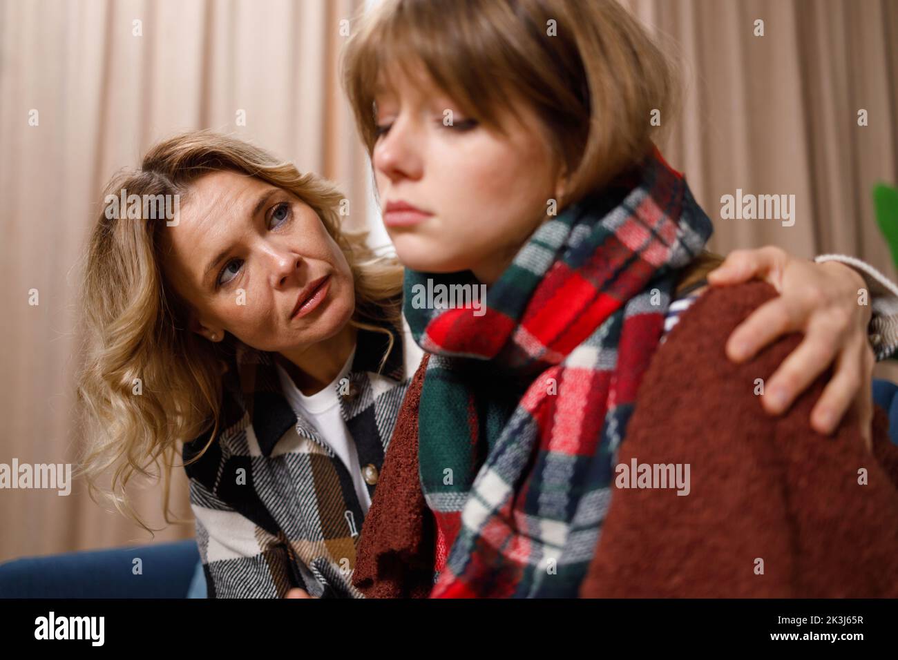 Mother supporting her flu-sick daughter. Woman supports a sad girl ...