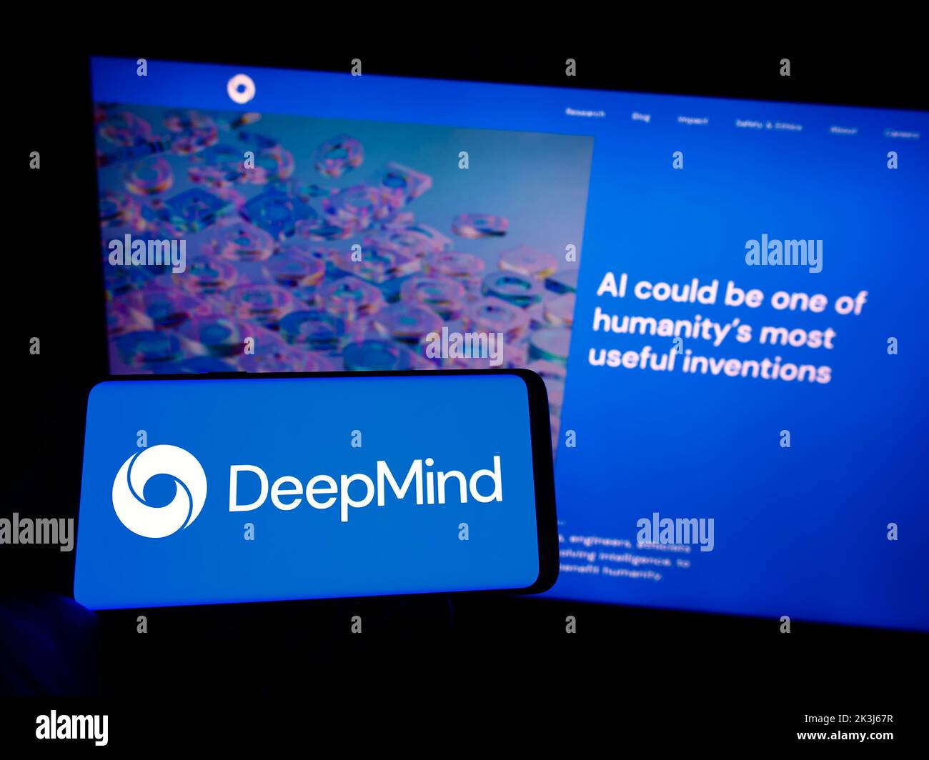 Person holding mobile phone with logo of AI company DeepMind ...