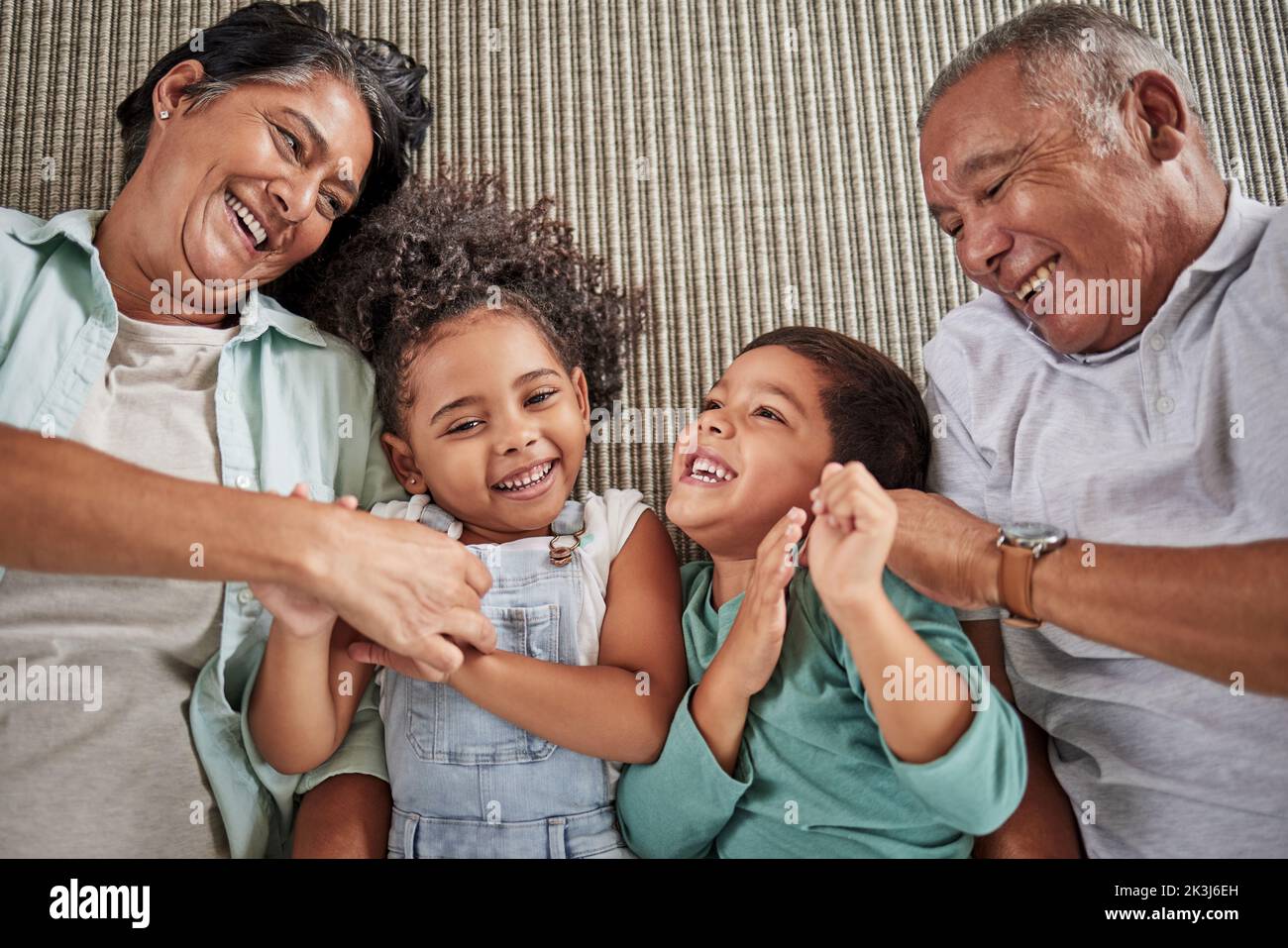 Happy family, grandparents and children on a sofa, relax and laughing ...