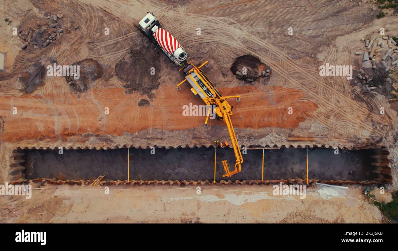 Lorry crane and a truck concrete mixer. Open-cut trench excavation and ...