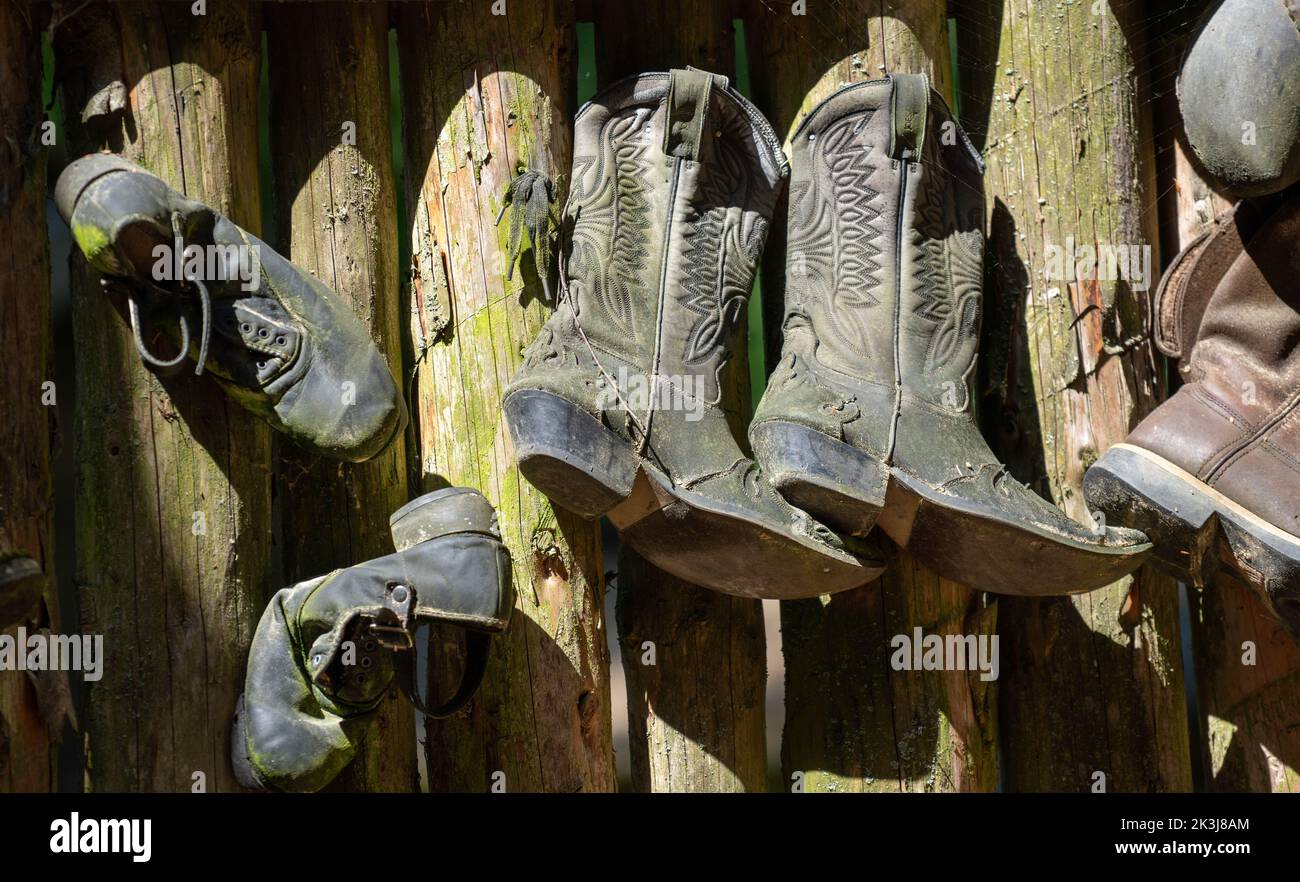 A variety of old cowboy boots hanging on wooden wall Stock Photo - Alamy