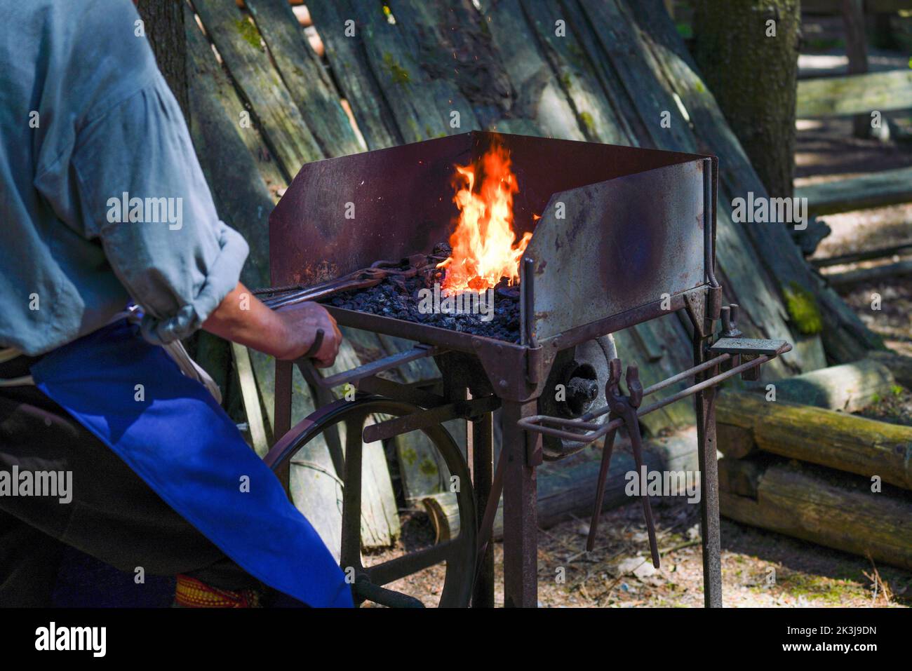 A professional blacksmith melting metal sticks on fire at work Stock ...