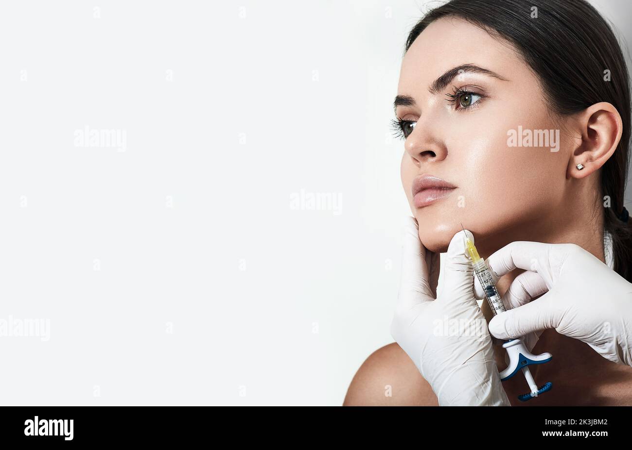 Syringe near woman's chin, beauty injections with fillers for chin ...