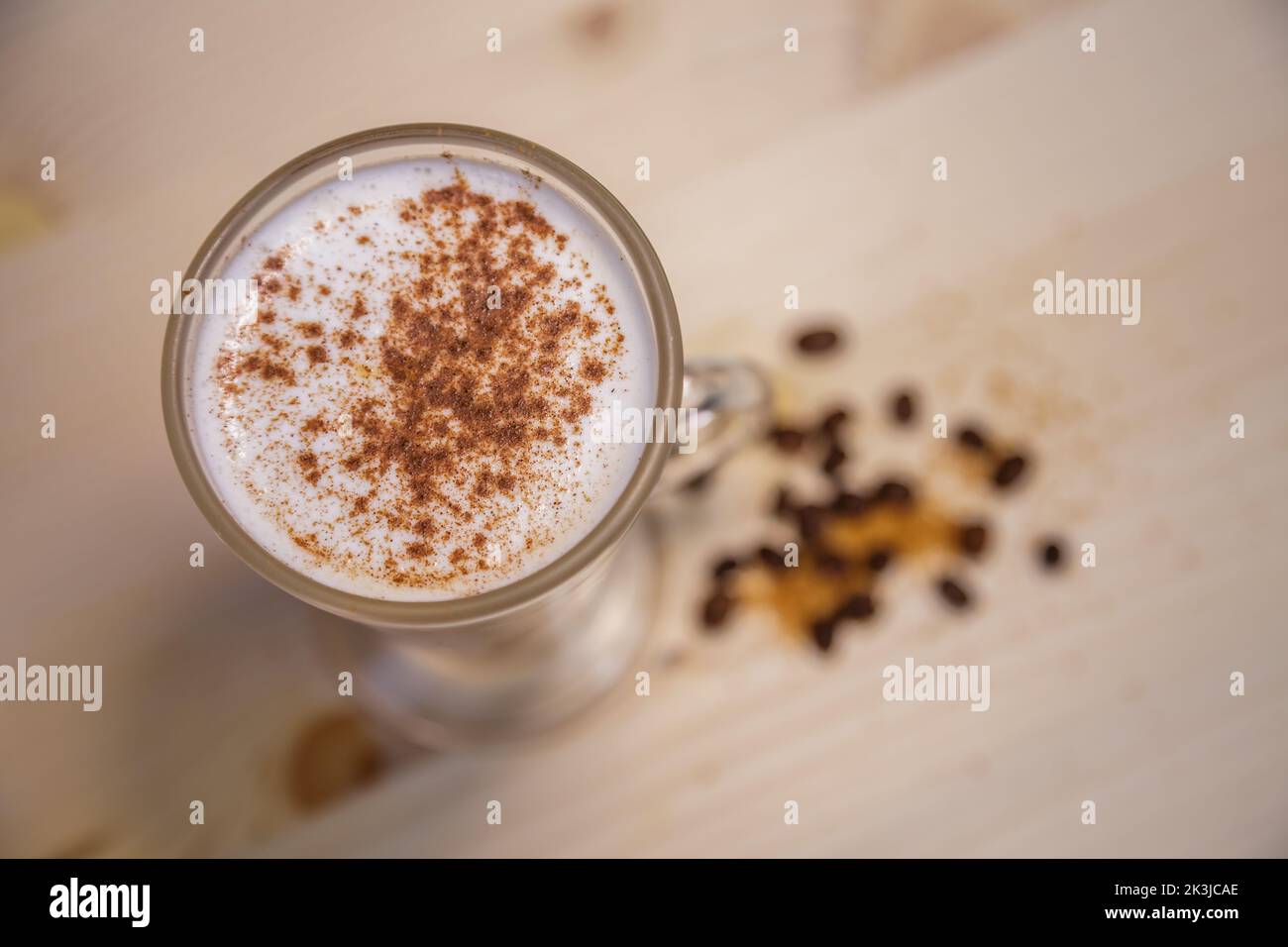 A top view of a freshly made coffee with whipped cream and coffee beans ...