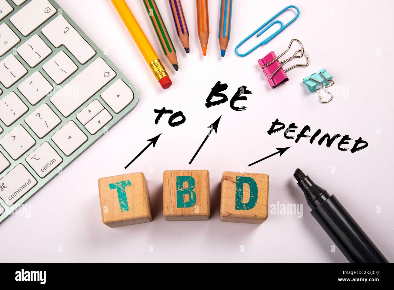 TBD - To Be Defined. Computer keyboard and stationery on a white table ...
