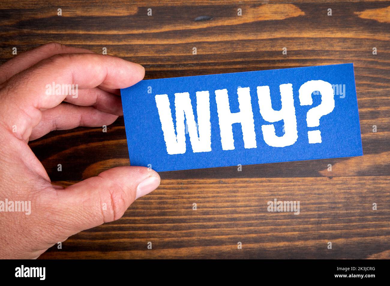 Why. Text on a blue background. Piece of paper in a man's hand Stock ...