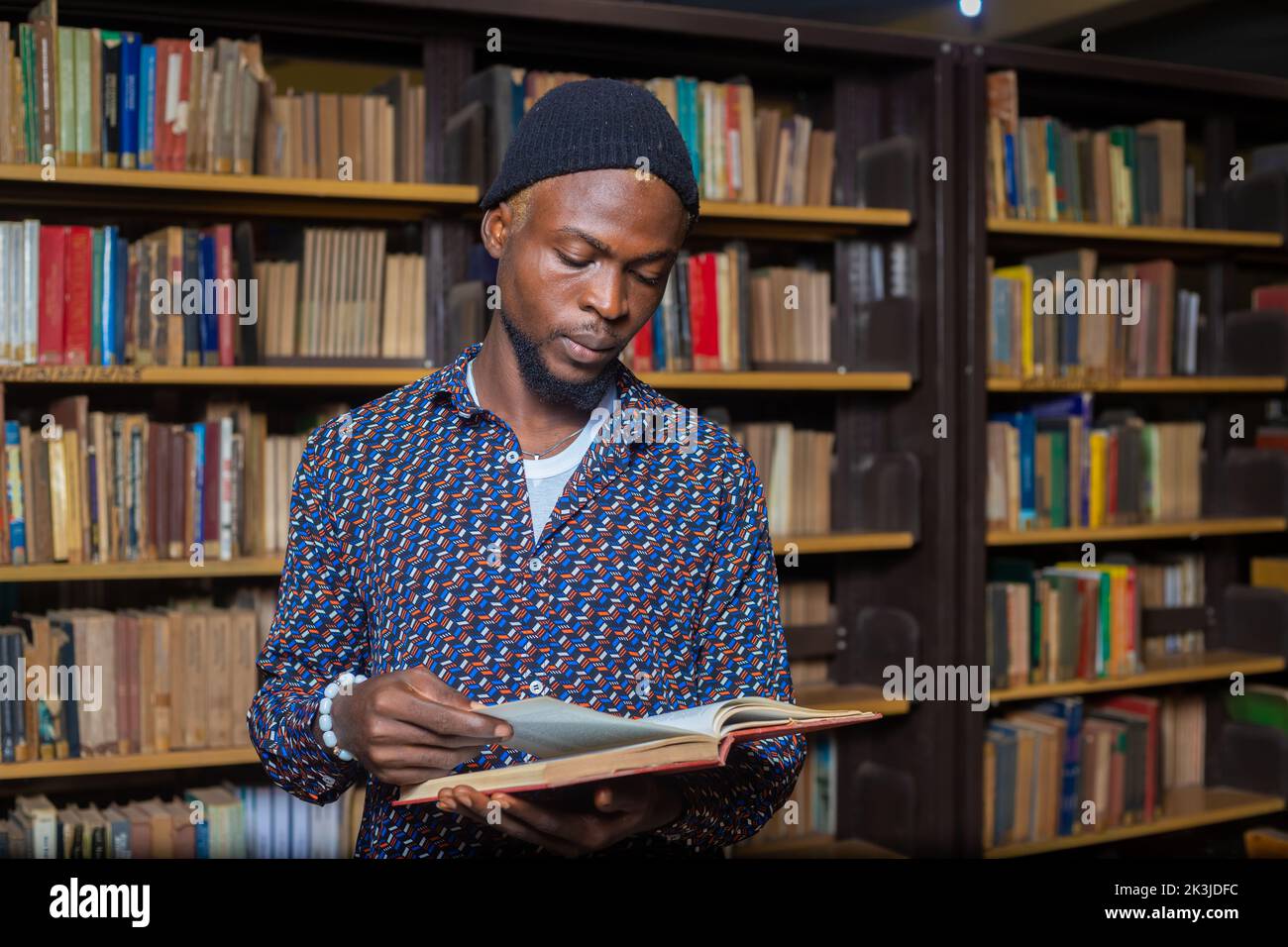 A closeup shot of an African boy reading a book in the library Stock ...