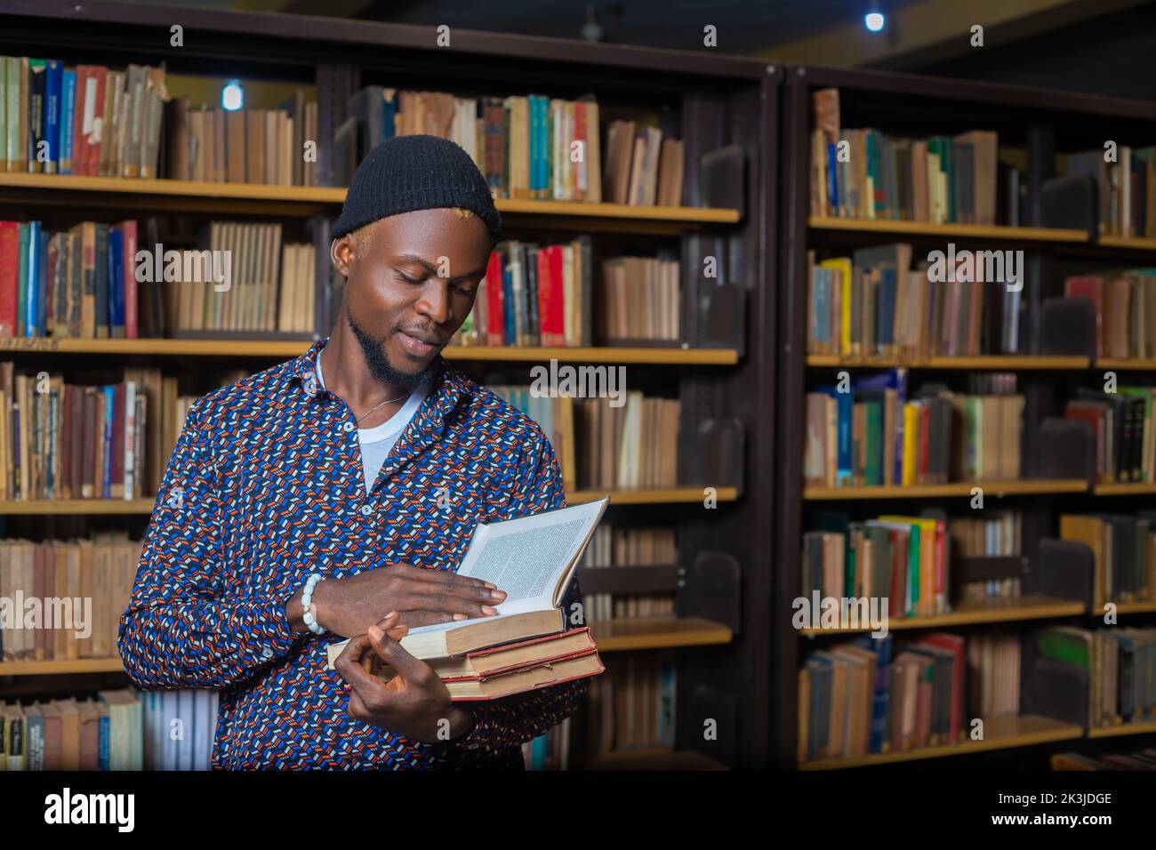 A closeup shot of an African boy reading a book in the library Stock ...