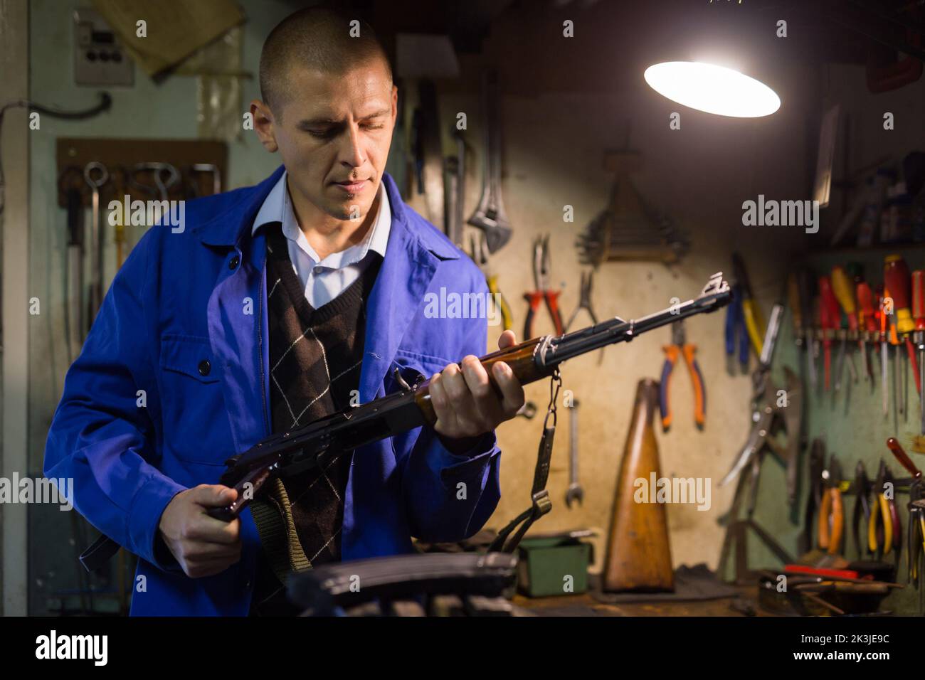 Gunsmith performing maintenance of Kalashnikov assault rifle in ...