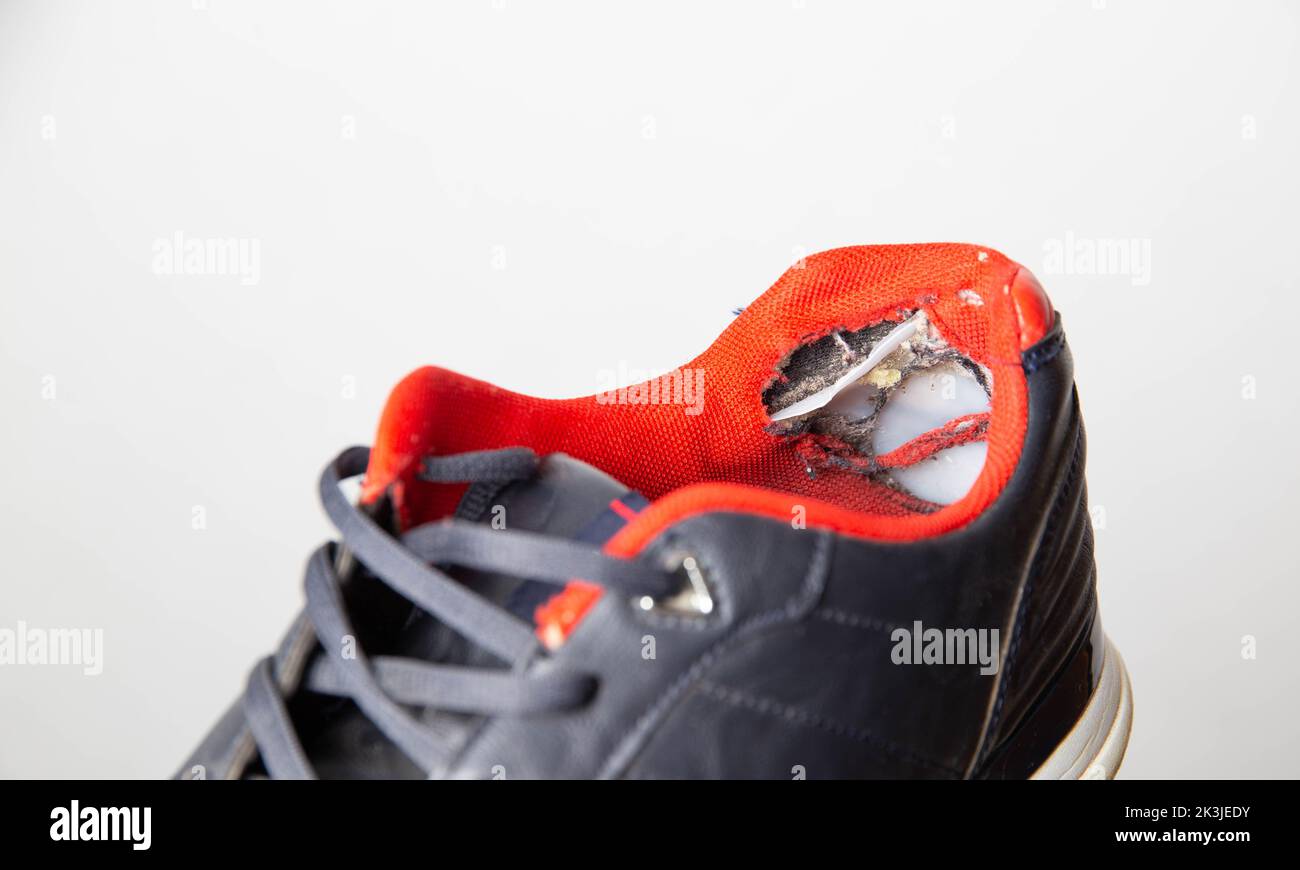 Torn backs in multicolored sports sneakers on a white background ...