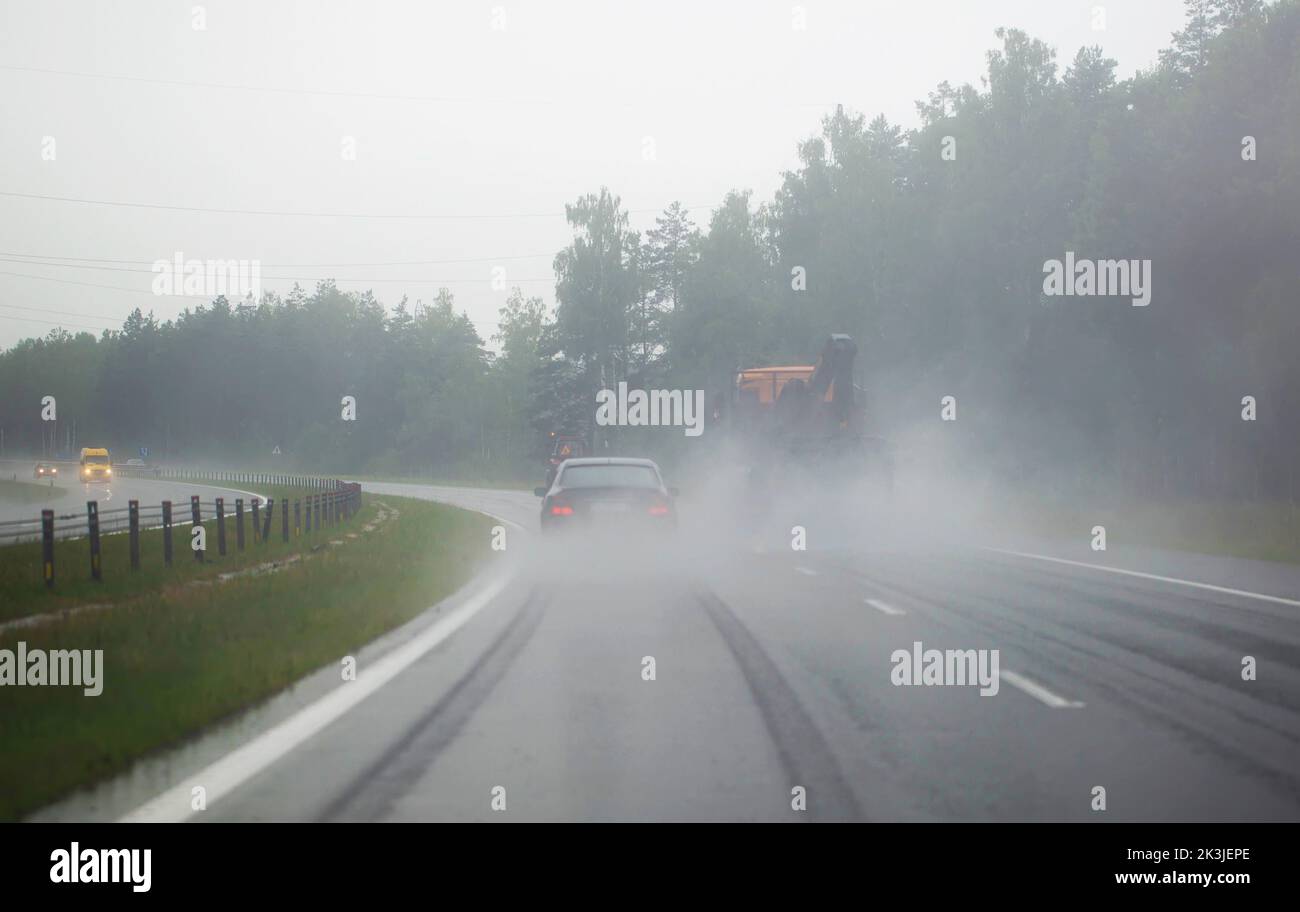 Traffic from cars on a rainy slippery road. Fog and poor visibility on ...