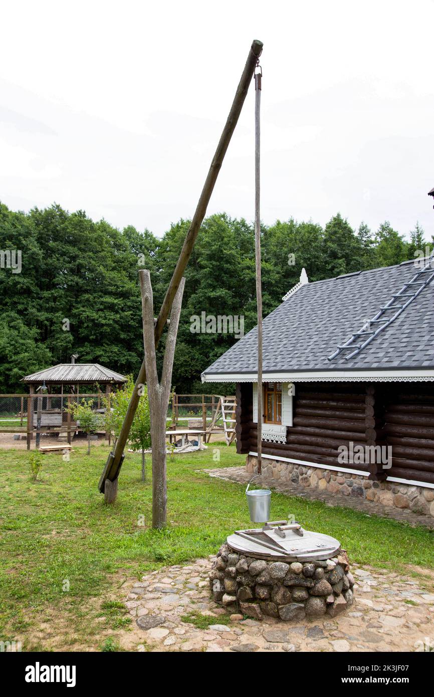 Crane well in the village on the background of a rustic wooden house ...