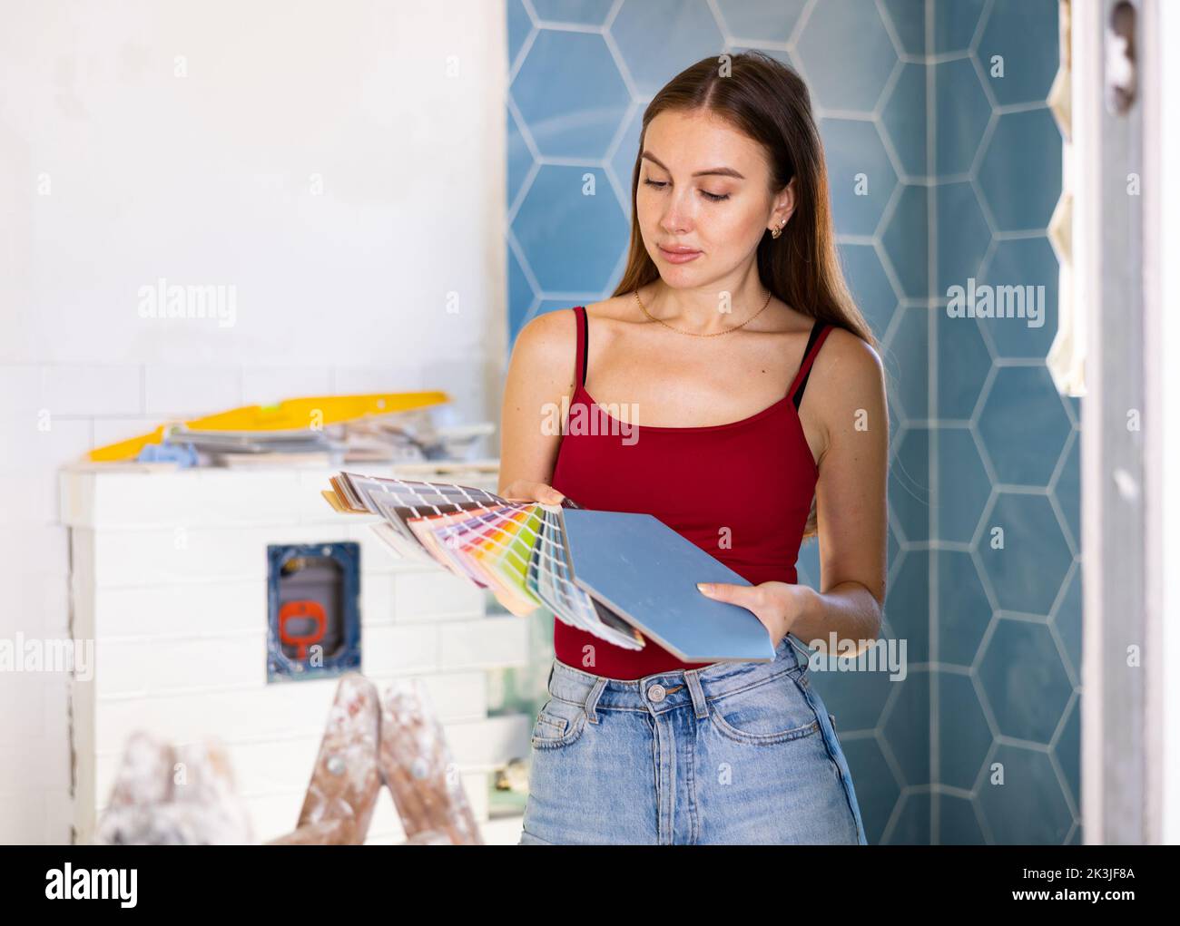Young woman with palette of colors in hands selects harmonious color of ...